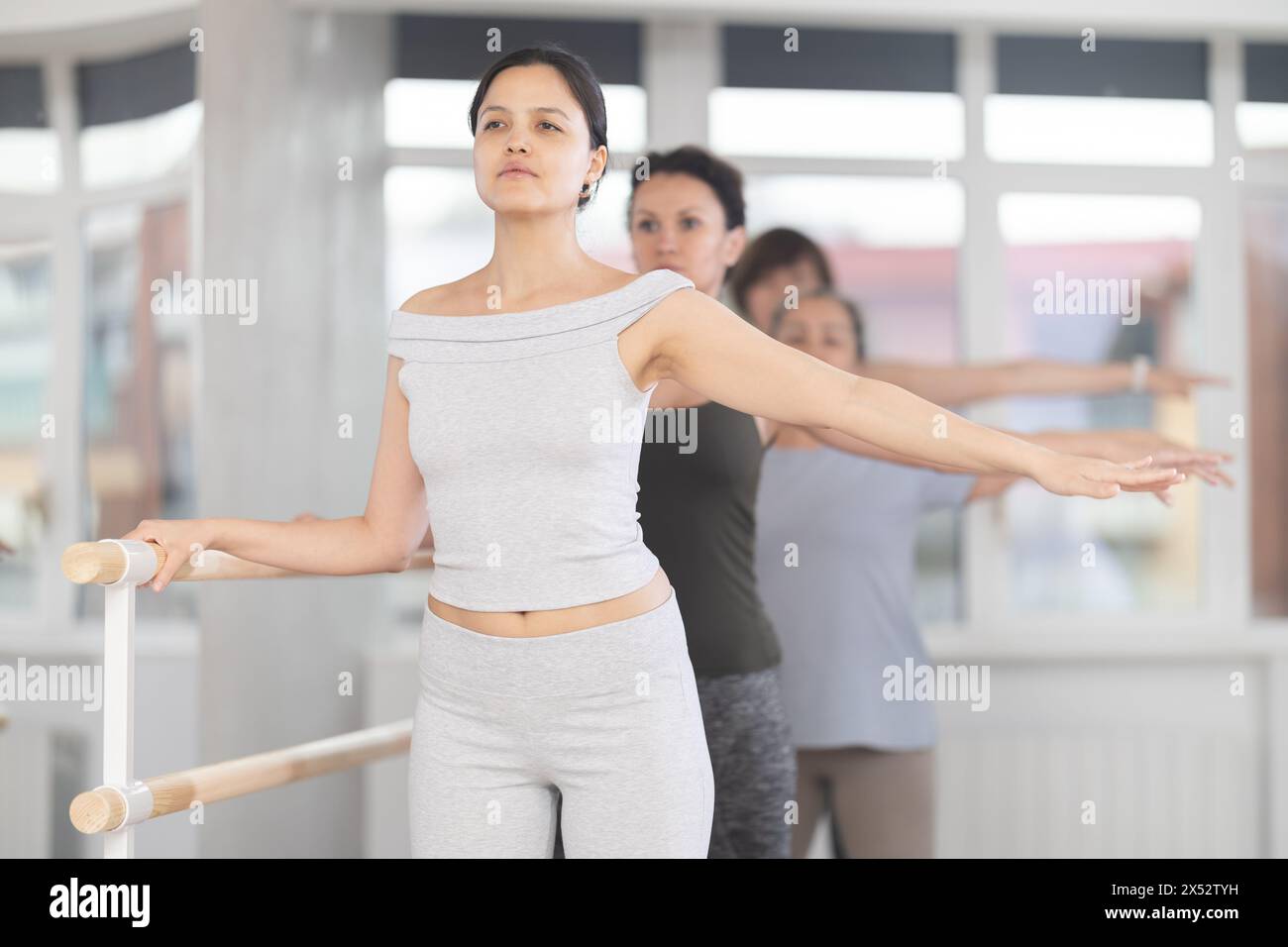 Group of women stand in second position at barre Stock Photo - Alamy