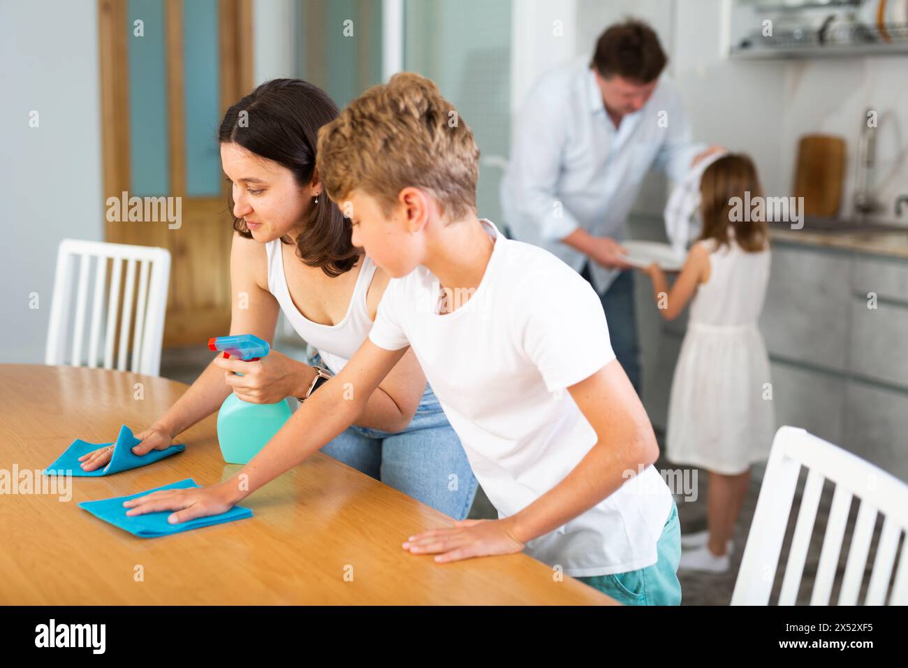 Happy family with two children doing cleaning in kitchen Stock Photo ...