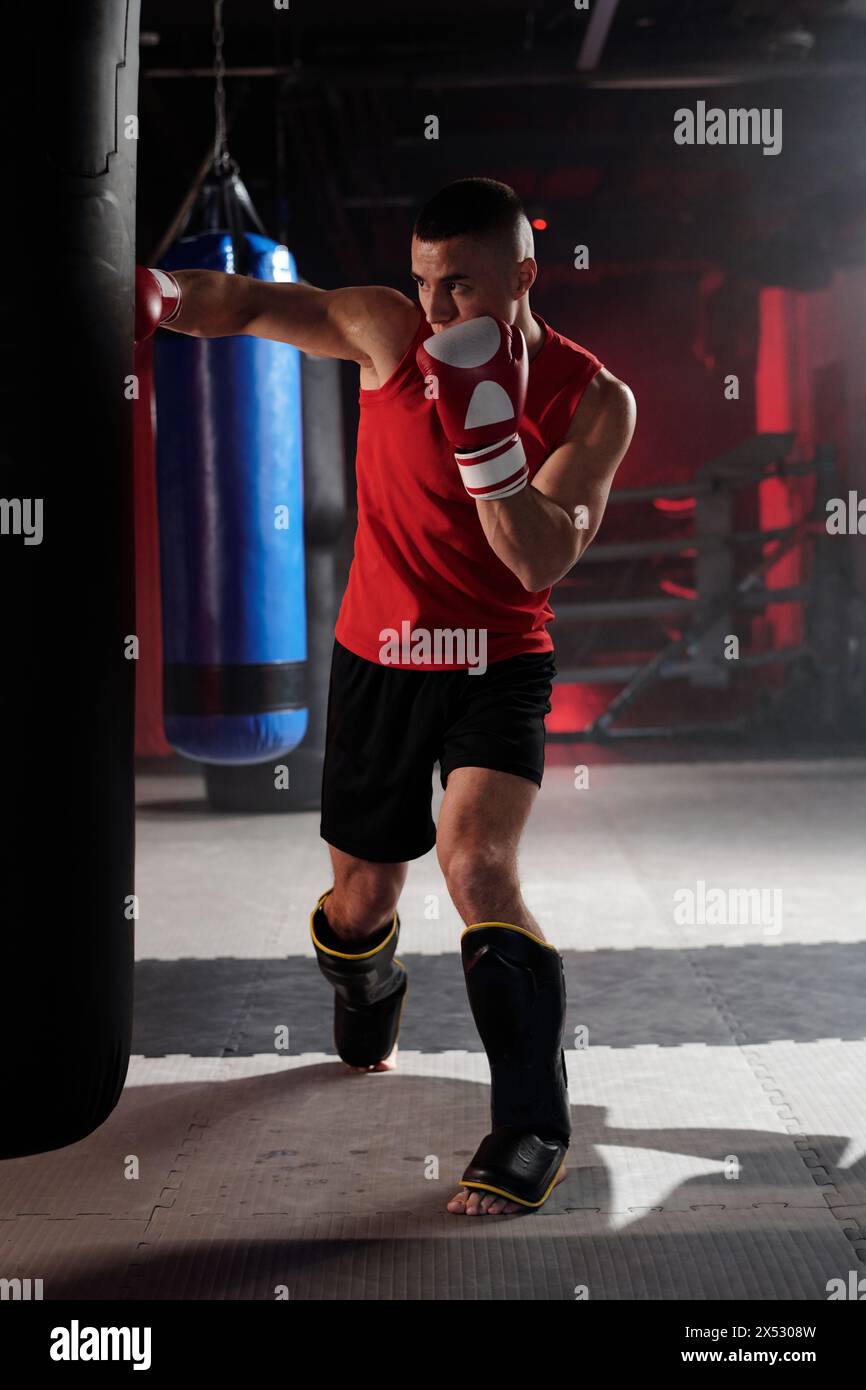 Full length portrait of young athlete in sportswear standing on boxing ...