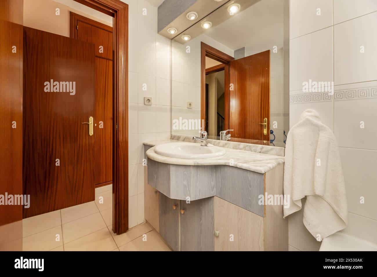 Toilet of a home with a sink cabinet with integrated mirror Stock Photo ...