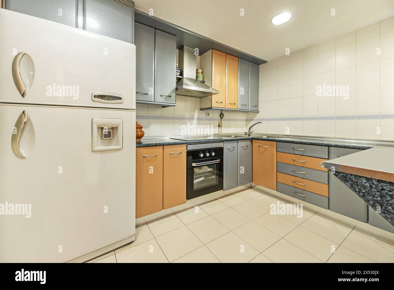 Kitchen with L-shaped base units, blue countertop and combined wood and ...