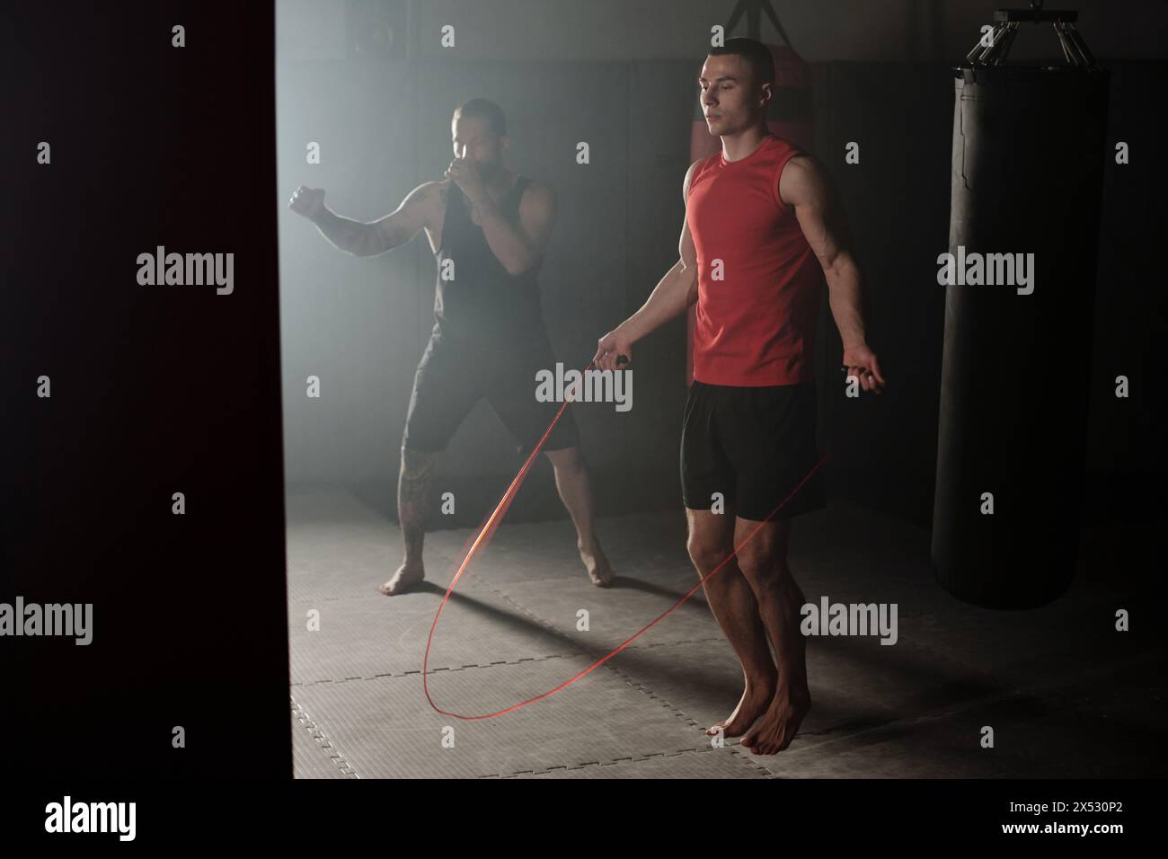 Light falling from window of gym on two young male athletes practicing ...