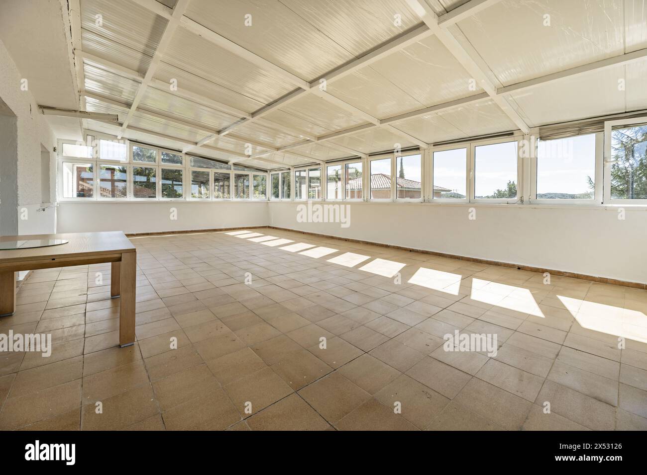 A large closed terrace with metal ceilings, light brown floors and the ...