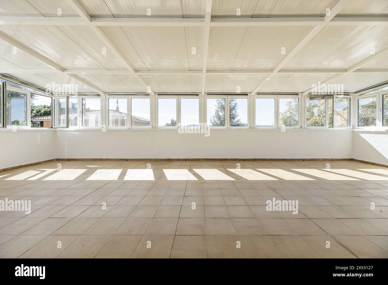 A large closed terrace with metal roofs, light brown floors and the ...