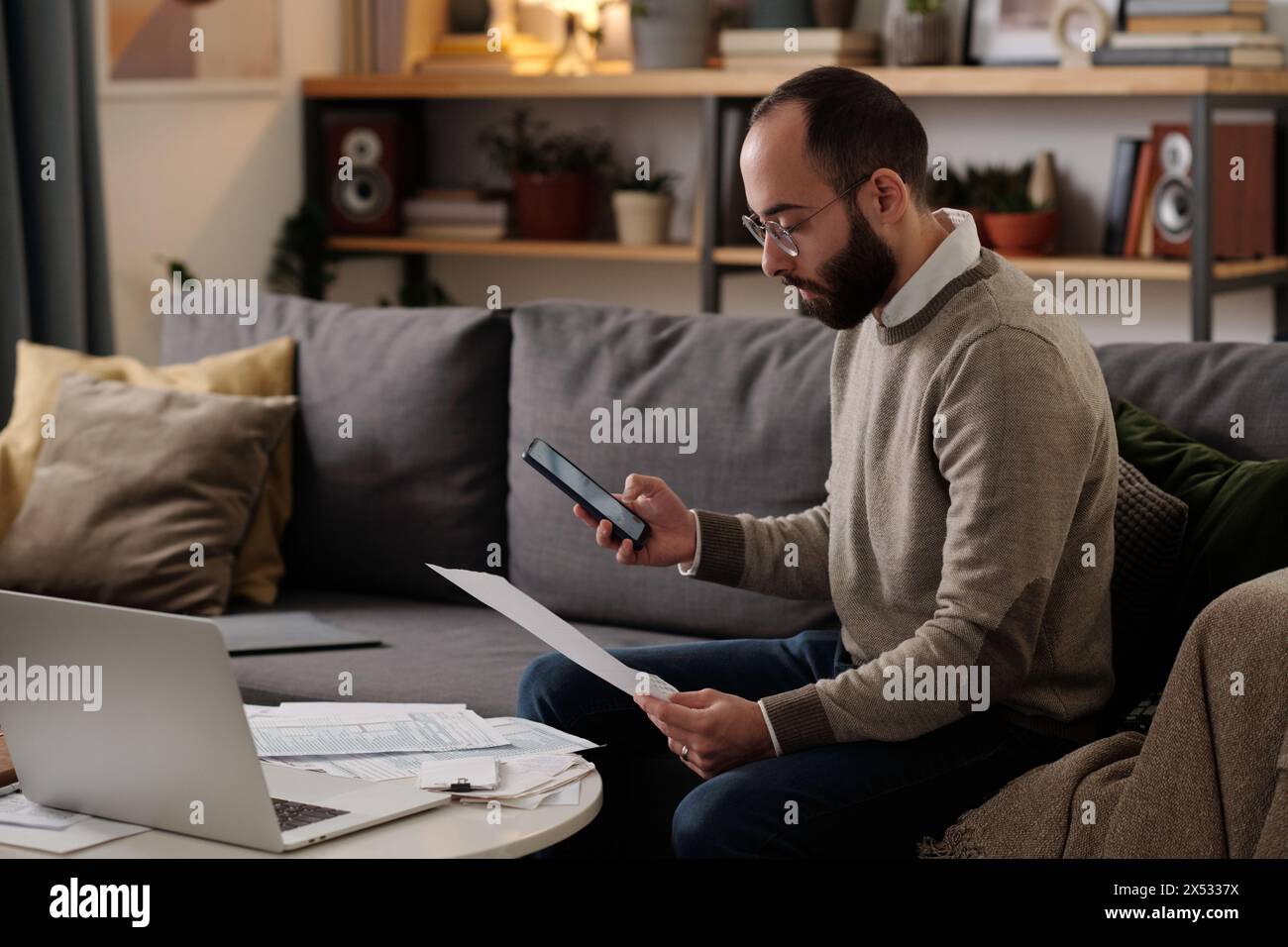 Bearded man using calculator checking hi-res stock photography and ...