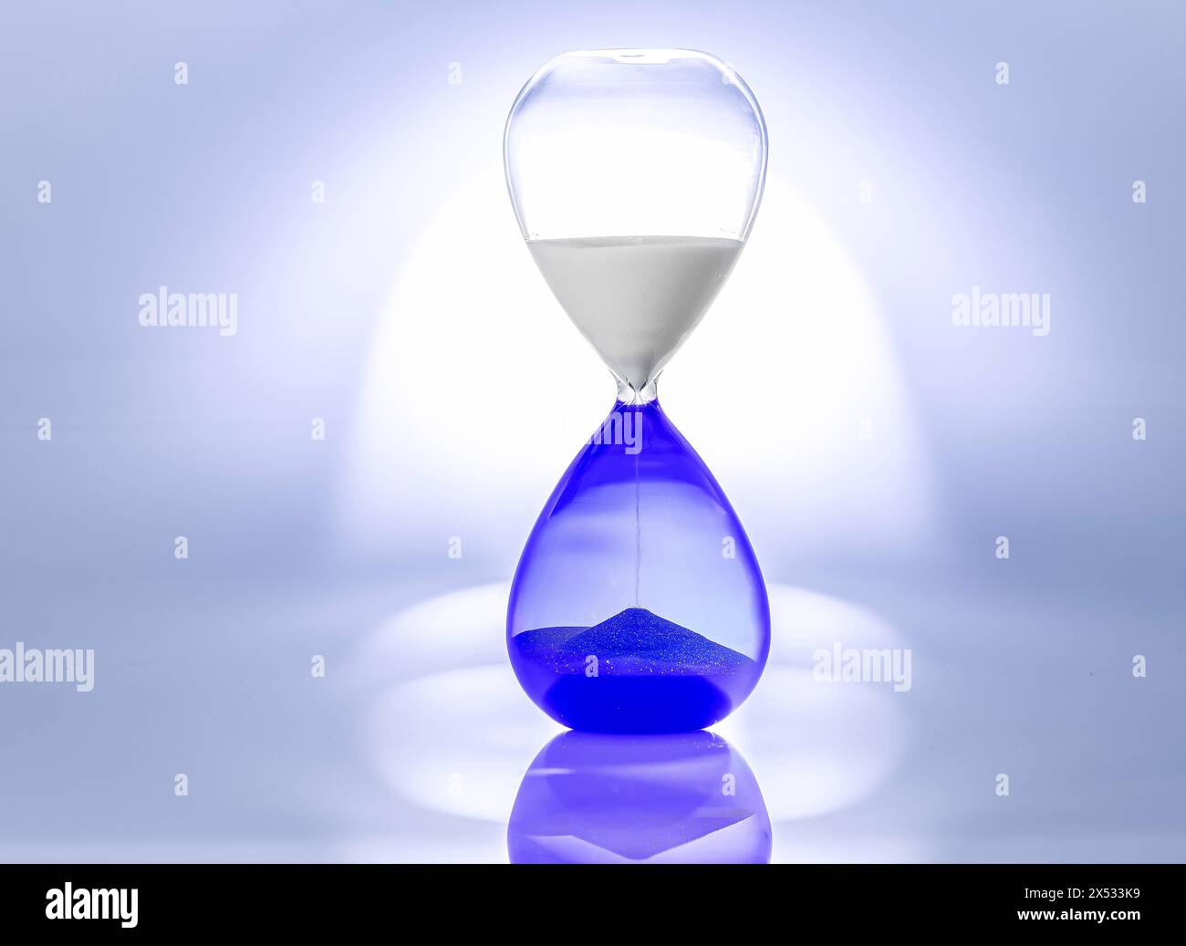 Transparent hourglass with blue sand and blue lighting, creates a shiny ...