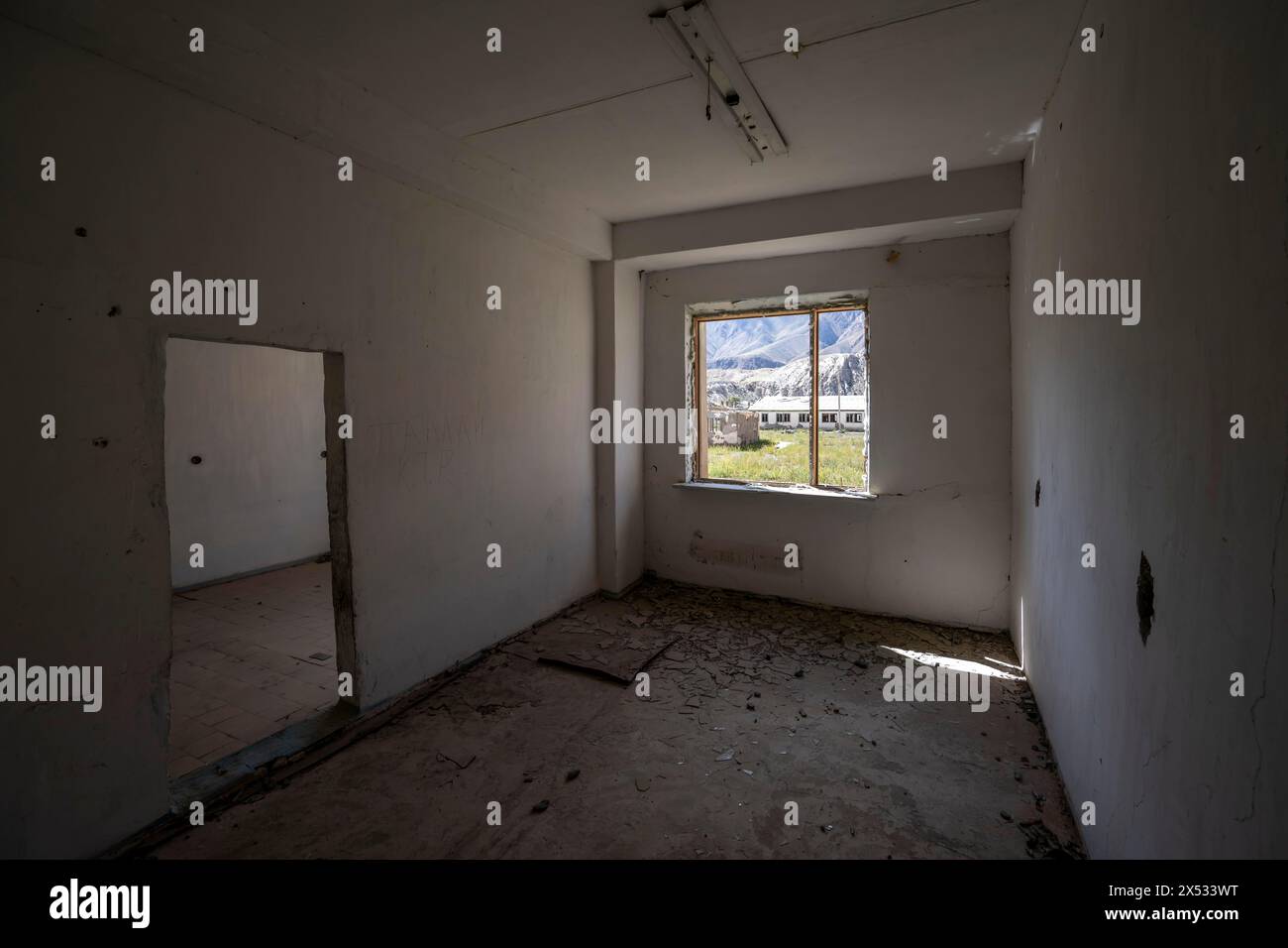 An abandoned, dilapidated room with a view of the mountains through the ...