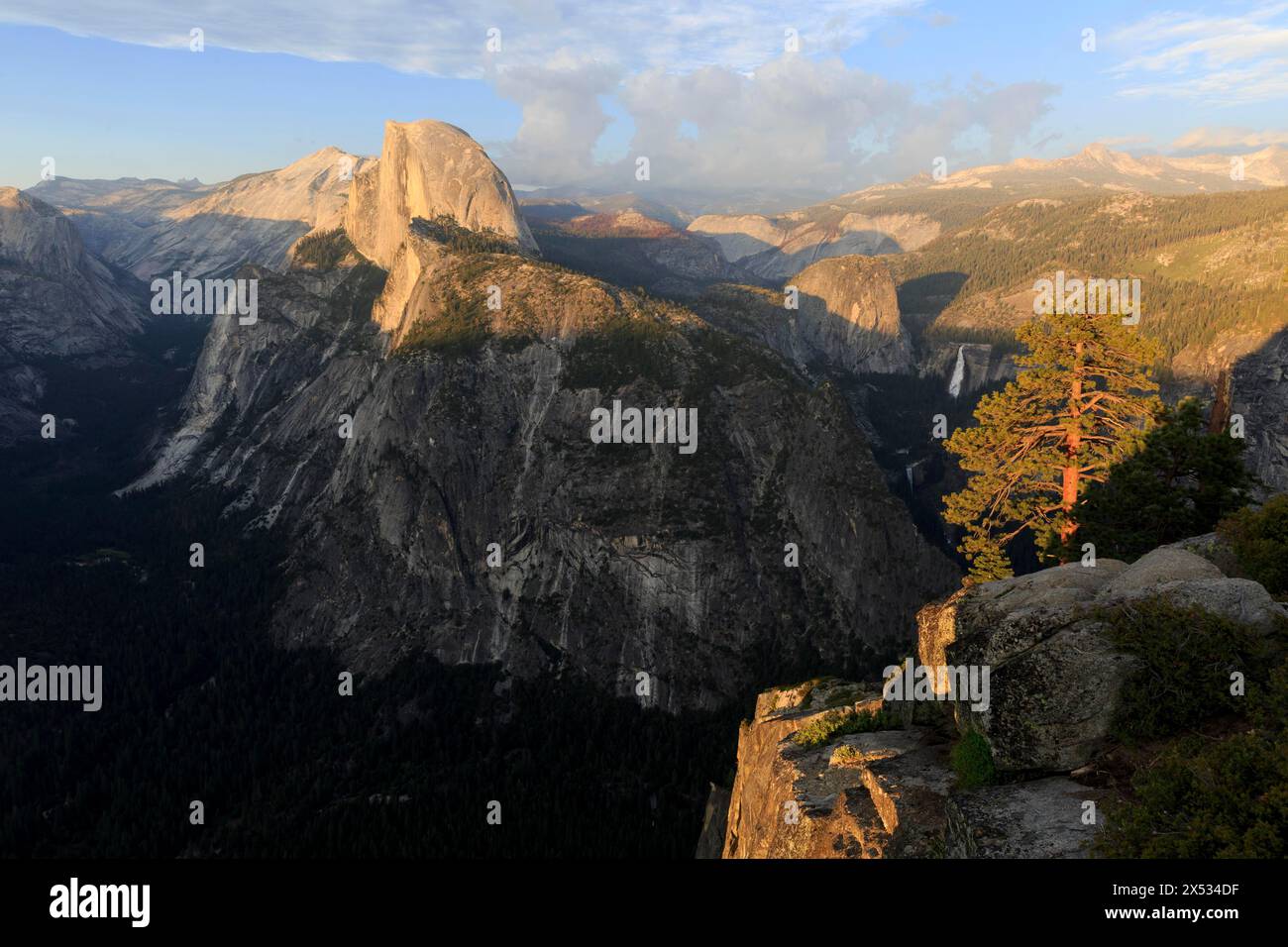 Warm evening light illuminates Half Dome and the surrounding cliffs of ...