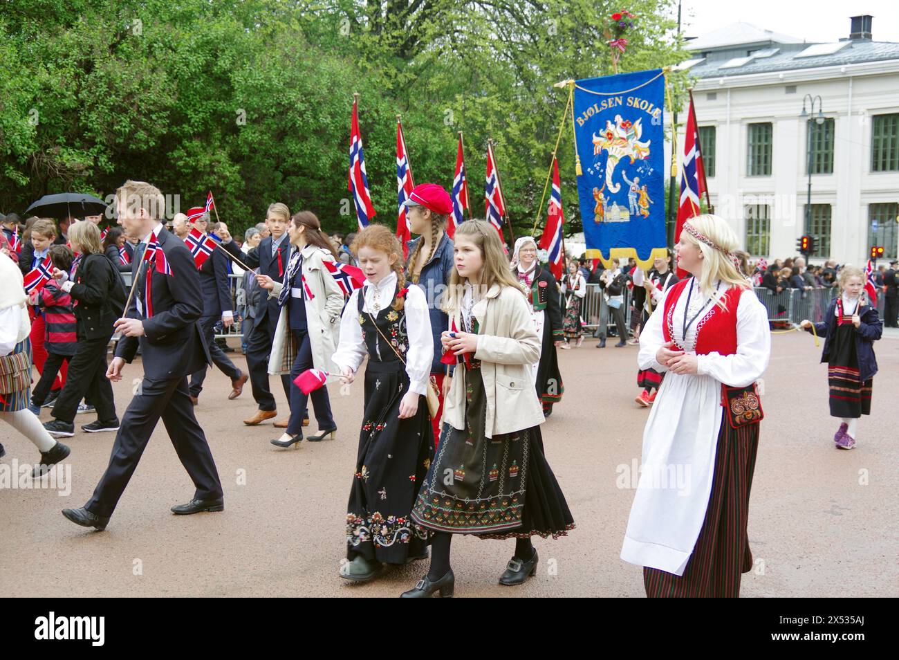 People in traditional costumes waving flags on the streets, folklore ...