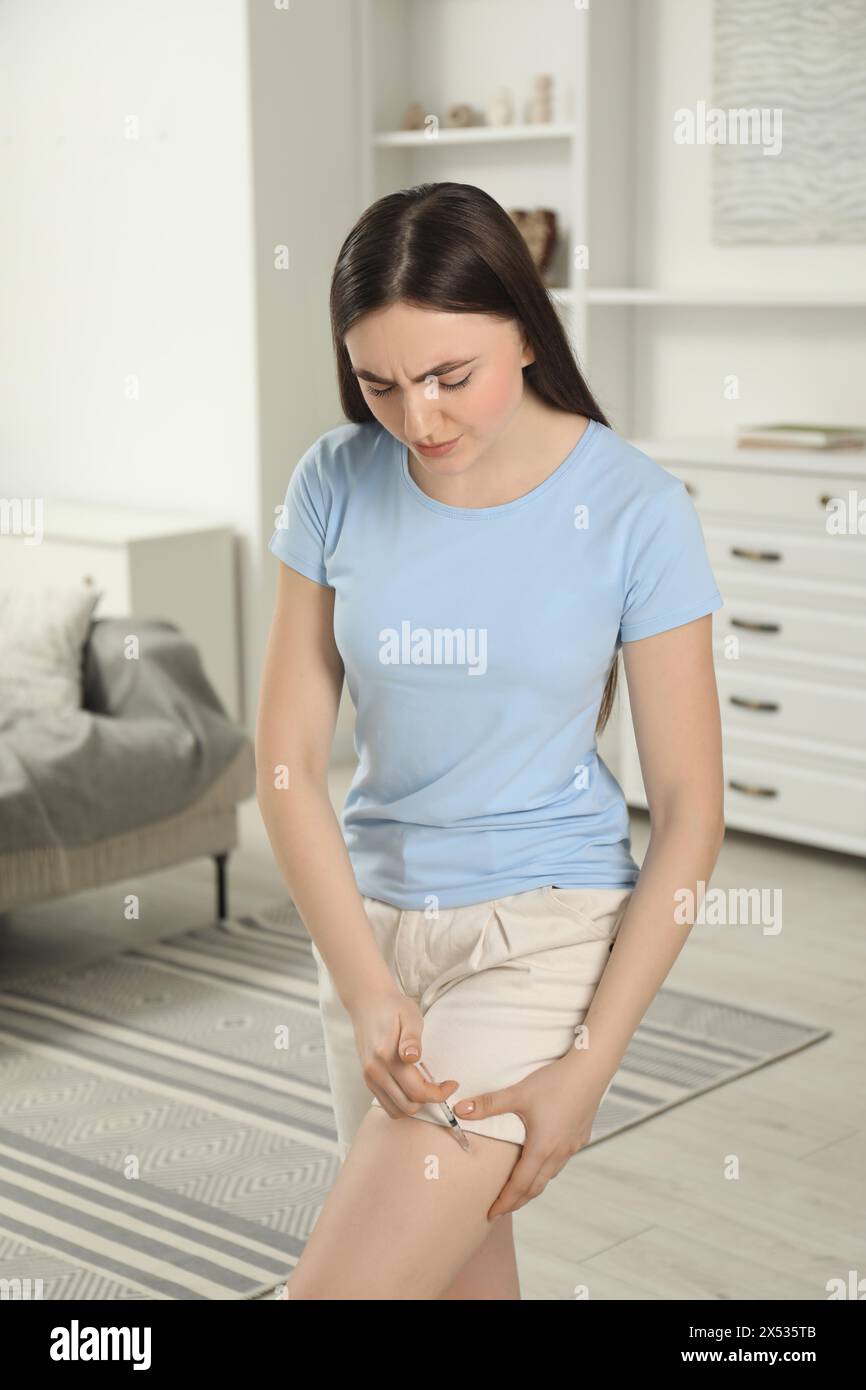 Diabetes. Woman making insulin injection into her leg at home Stock ...