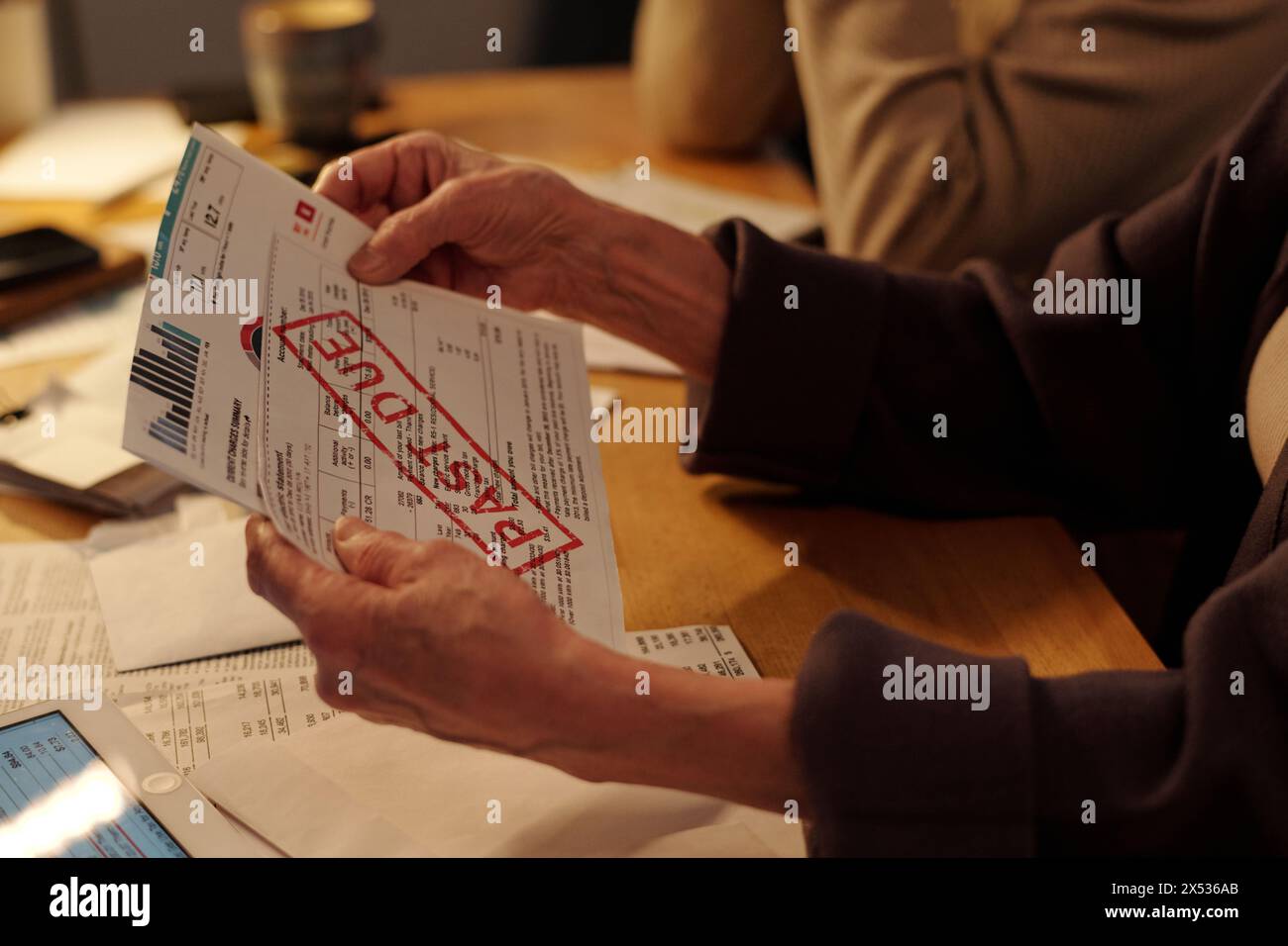 Hands of unrecognizable senior woman holding housing payment bill with ...