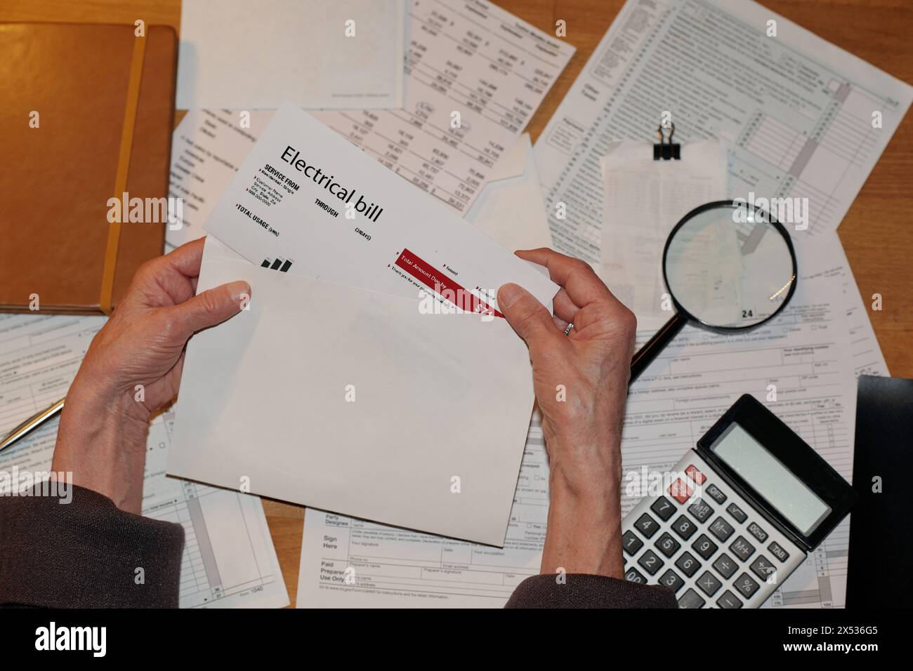 Top view of hands of senior unrecognizable woman taking electrical bill ...