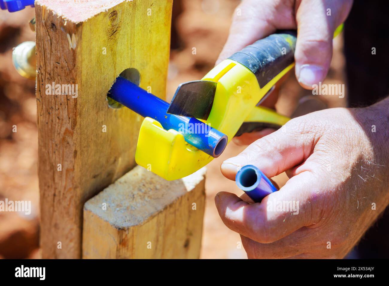 Plumber cutting blue plastic PVC water piping using saw tool Stock ...