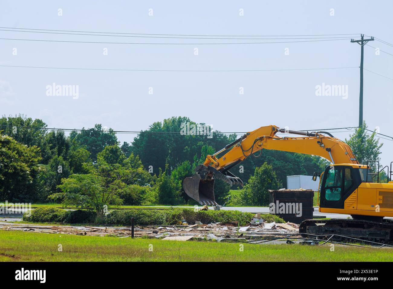 An excavator loads construction concrete waste into dump container on ...