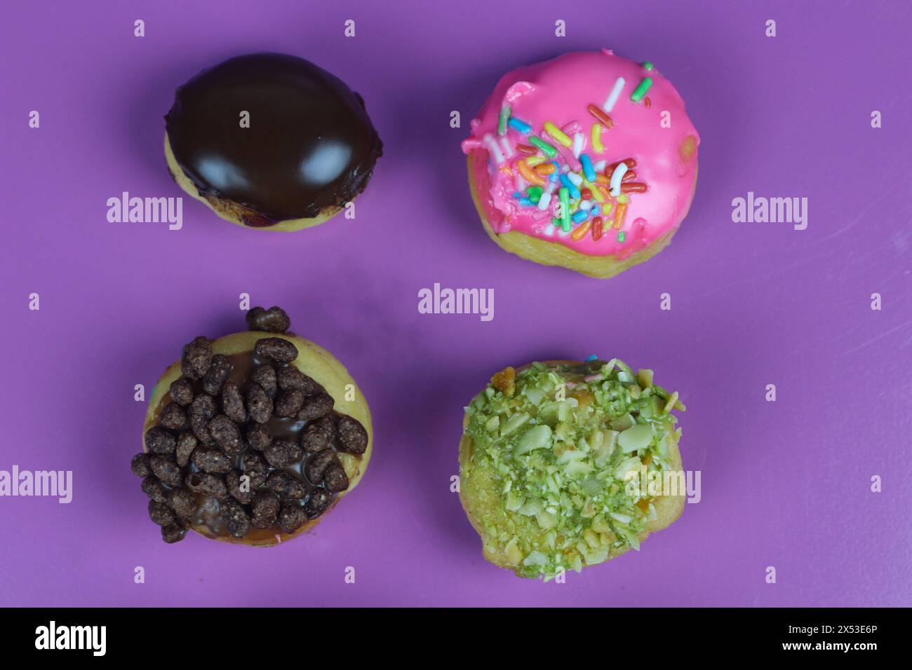 Donuts with colorful topping. Isolated purple background and copy space ...