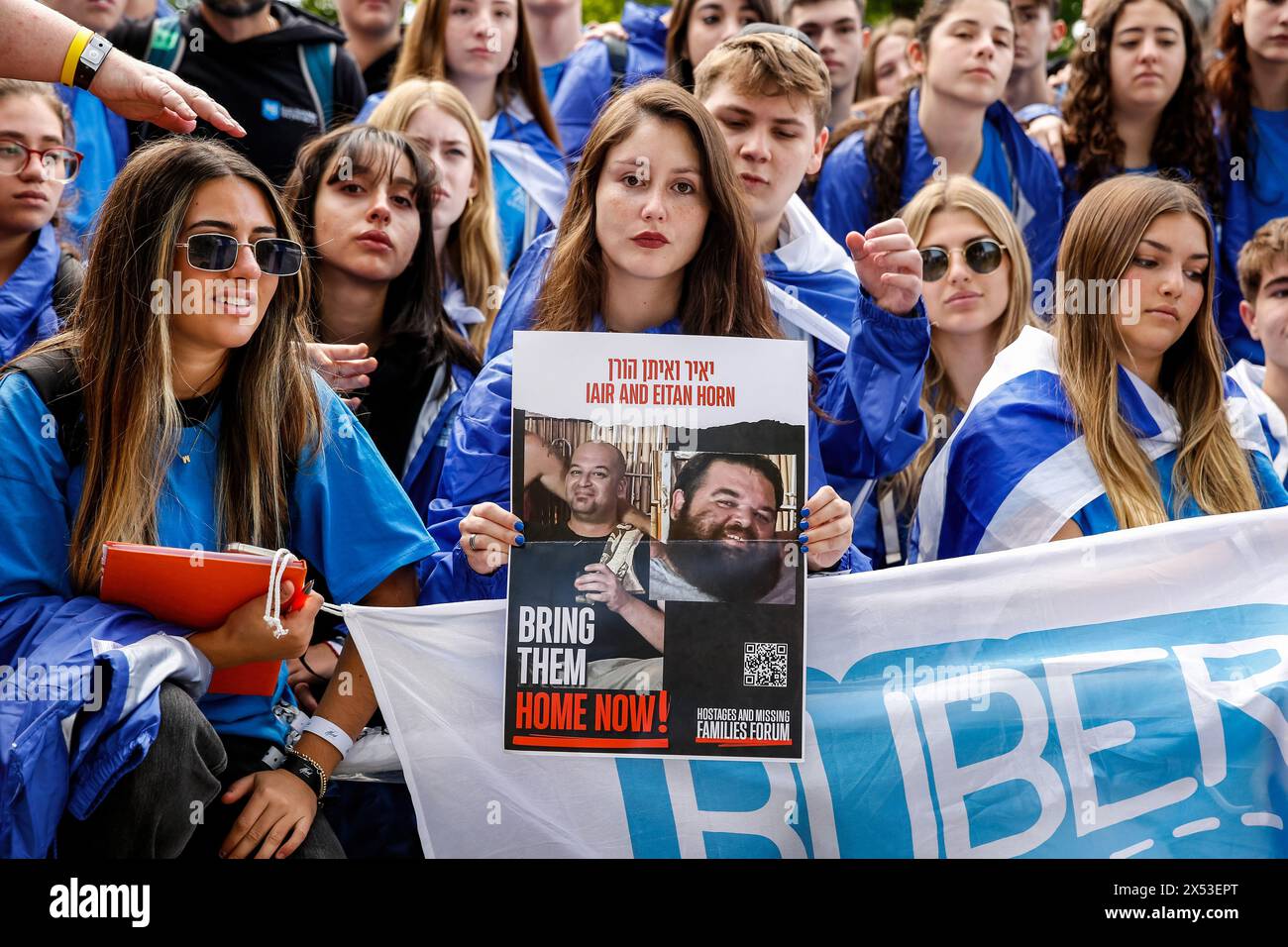 Visitors take souvenir photos with a placard of a 7 of October hostage ...