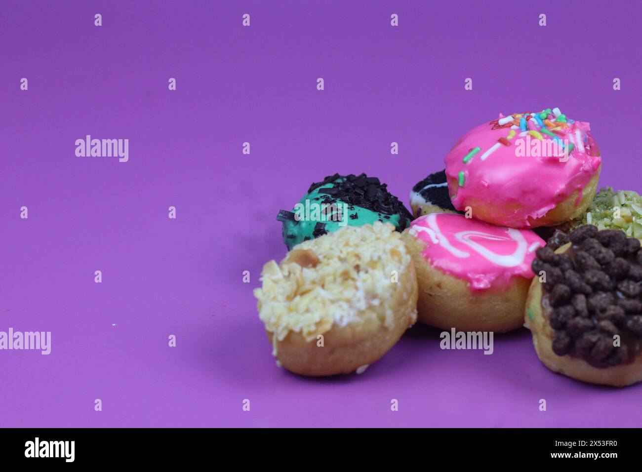 Donuts with colorful topping. Isolated purple background and copy space ...