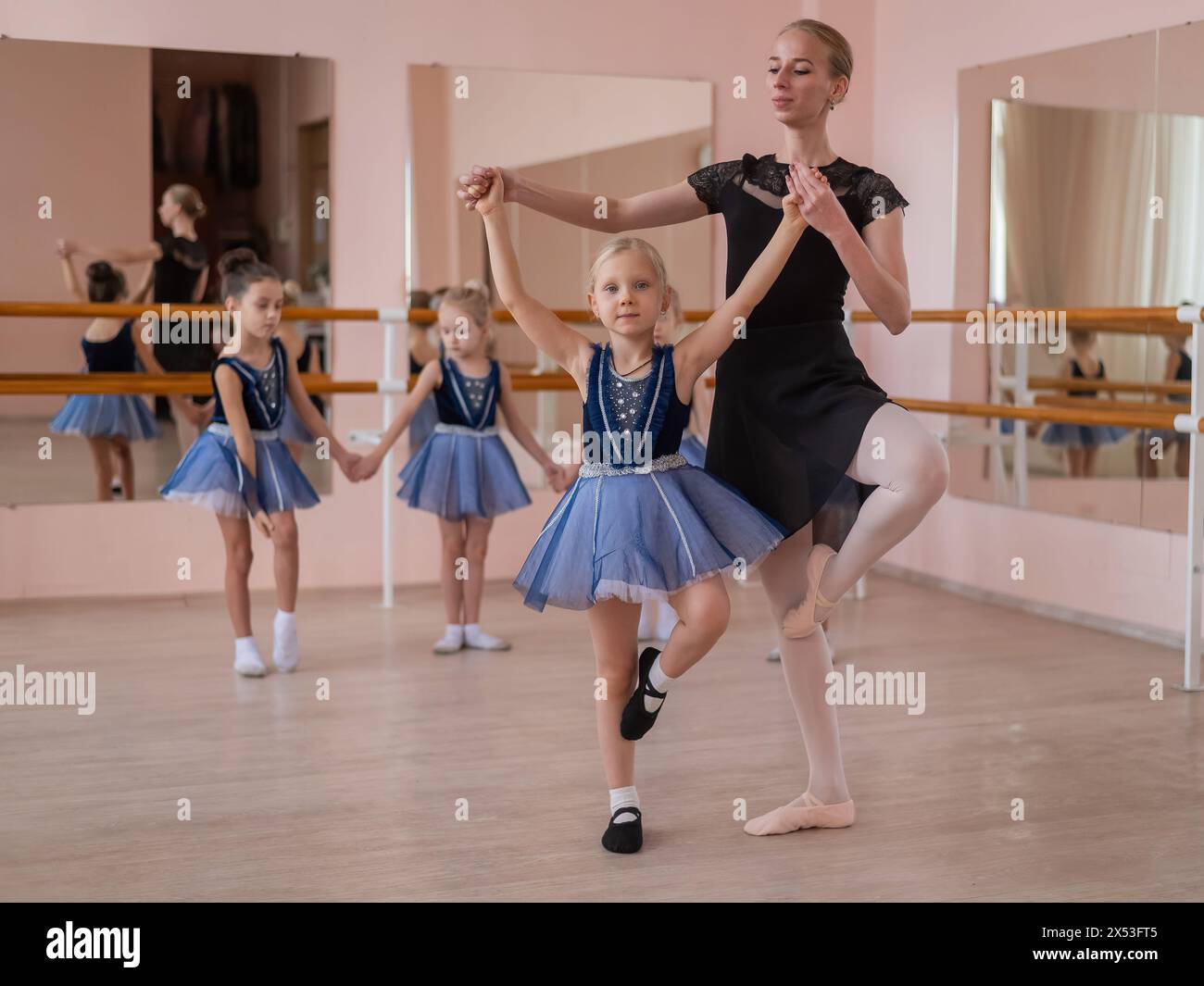 Children's ballet school. Caucasian woman teaching ballet to little ...