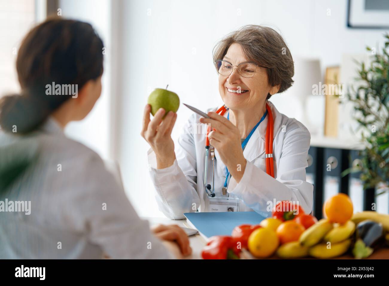 Happy doctor is working in medicine office. A woman is talking to a ...