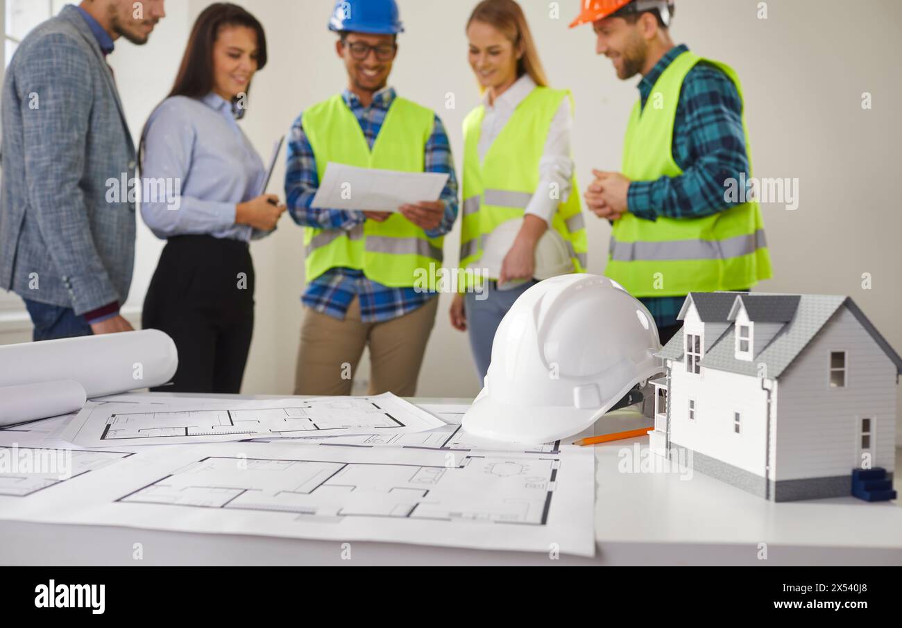 Engineers and architects discussing plans for a new home and working on ...