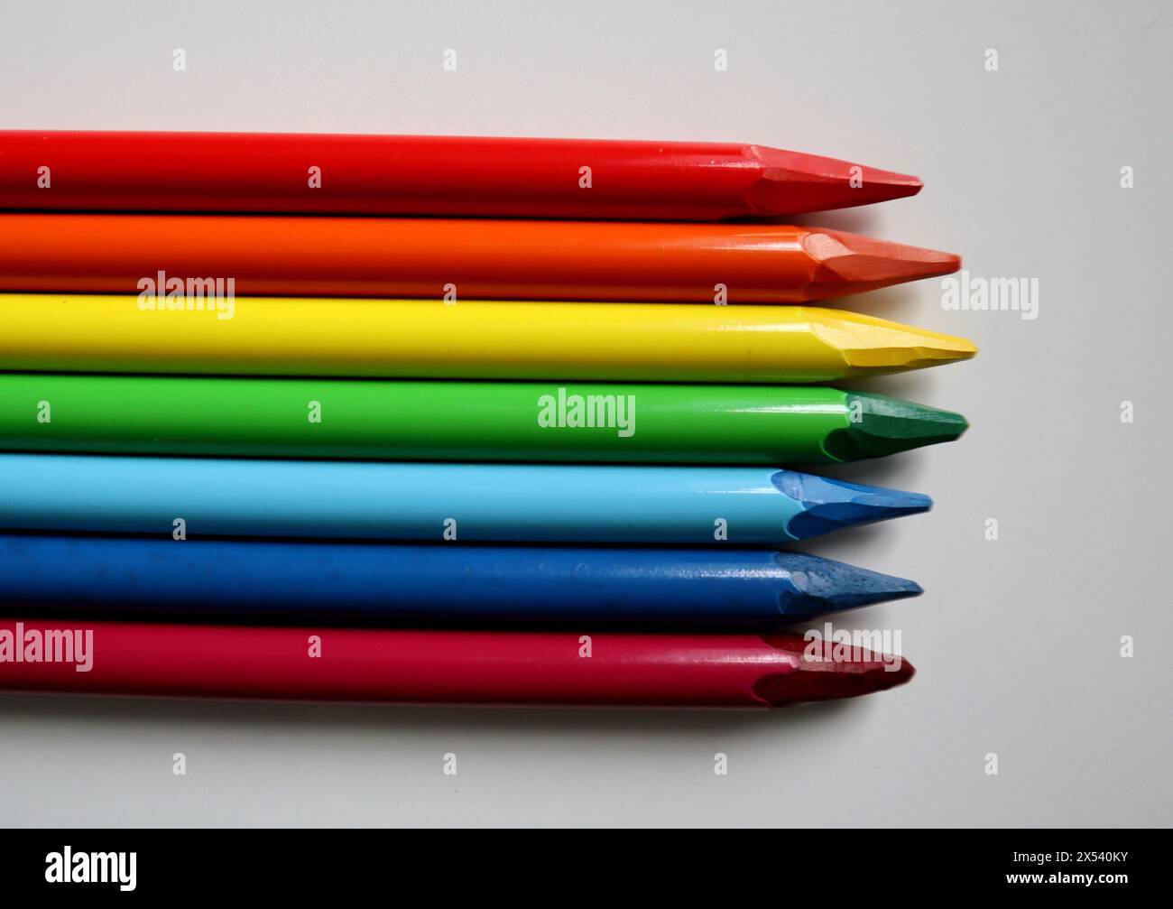 Photo of colored pencils arranged in the colors of the rainbow on white ...