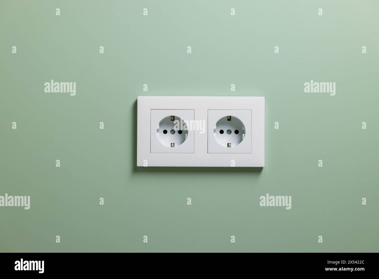 Electric power sockets on light green wall indoors Stock Photo - Alamy