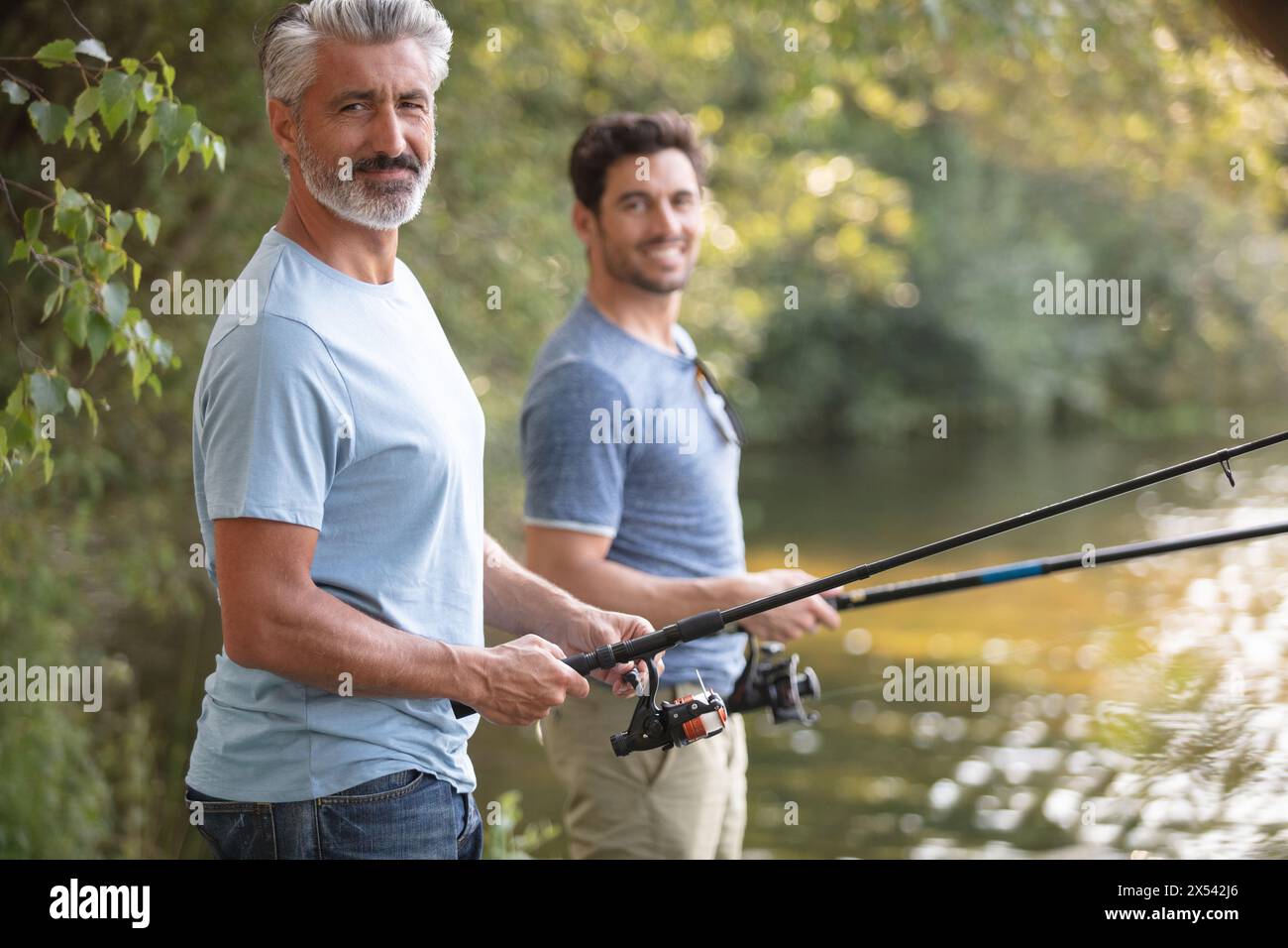 two male friends fishing in the lake Stock Photo - Alamy