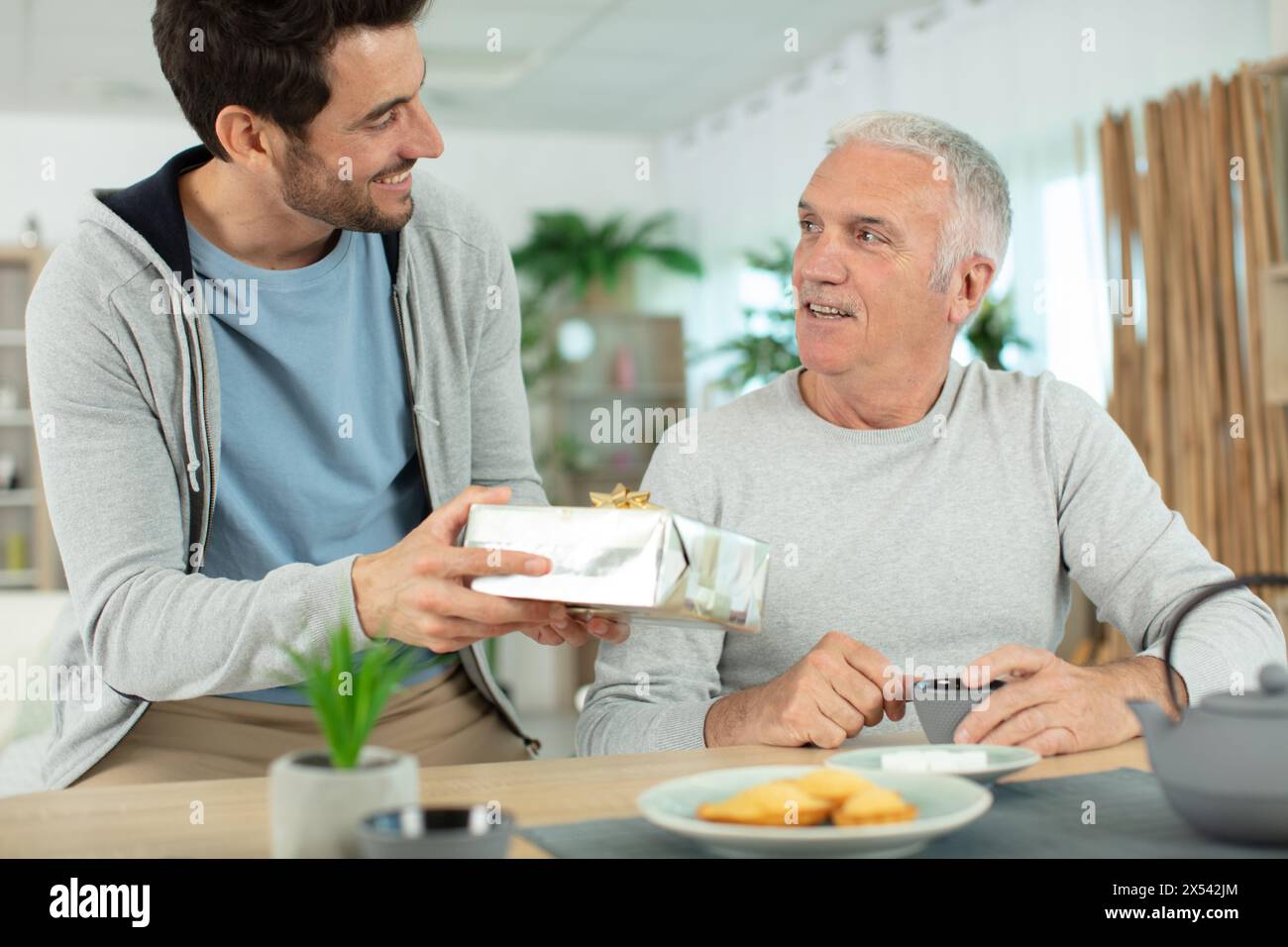 one man giving a present to another man Stock Photo - Alamy