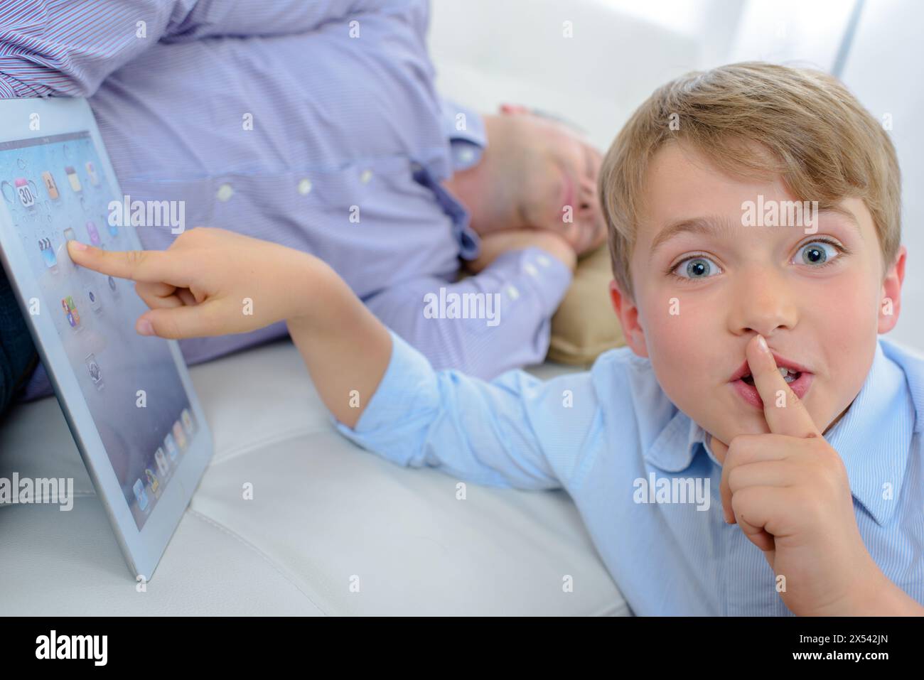 a sneaky child using a tablet Stock Photo - Alamy