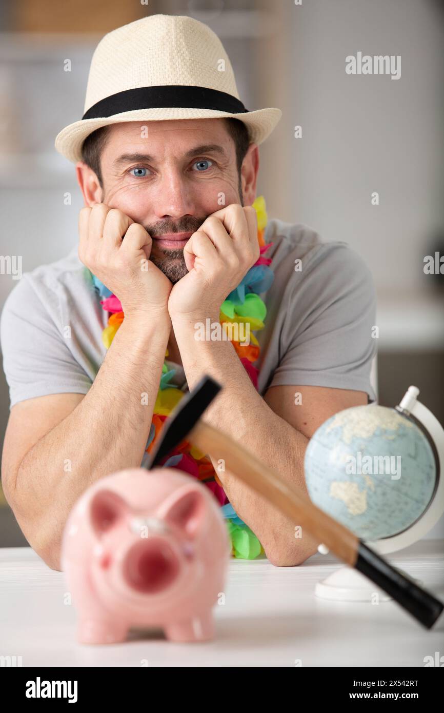 sad man with globe hammer and piggybank Stock Photo - Alamy