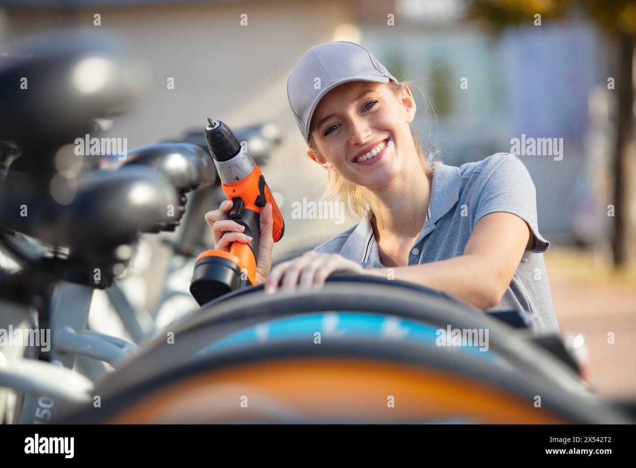 happy woman fixing a bicycle Stock Photo - Alamy