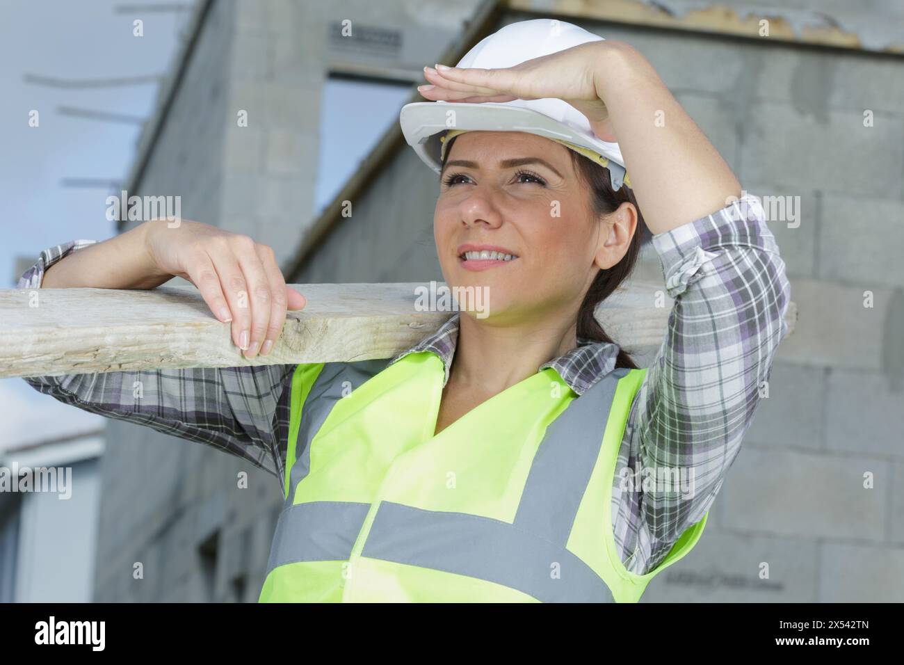 female builder carrying wood on site Stock Photo - Alamy