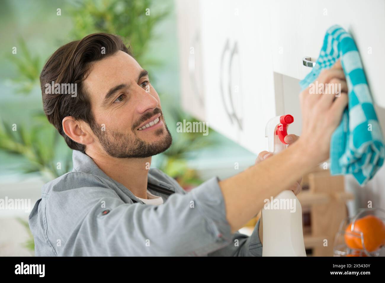 man cleaning using a spray detergent Stock Photo - Alamy