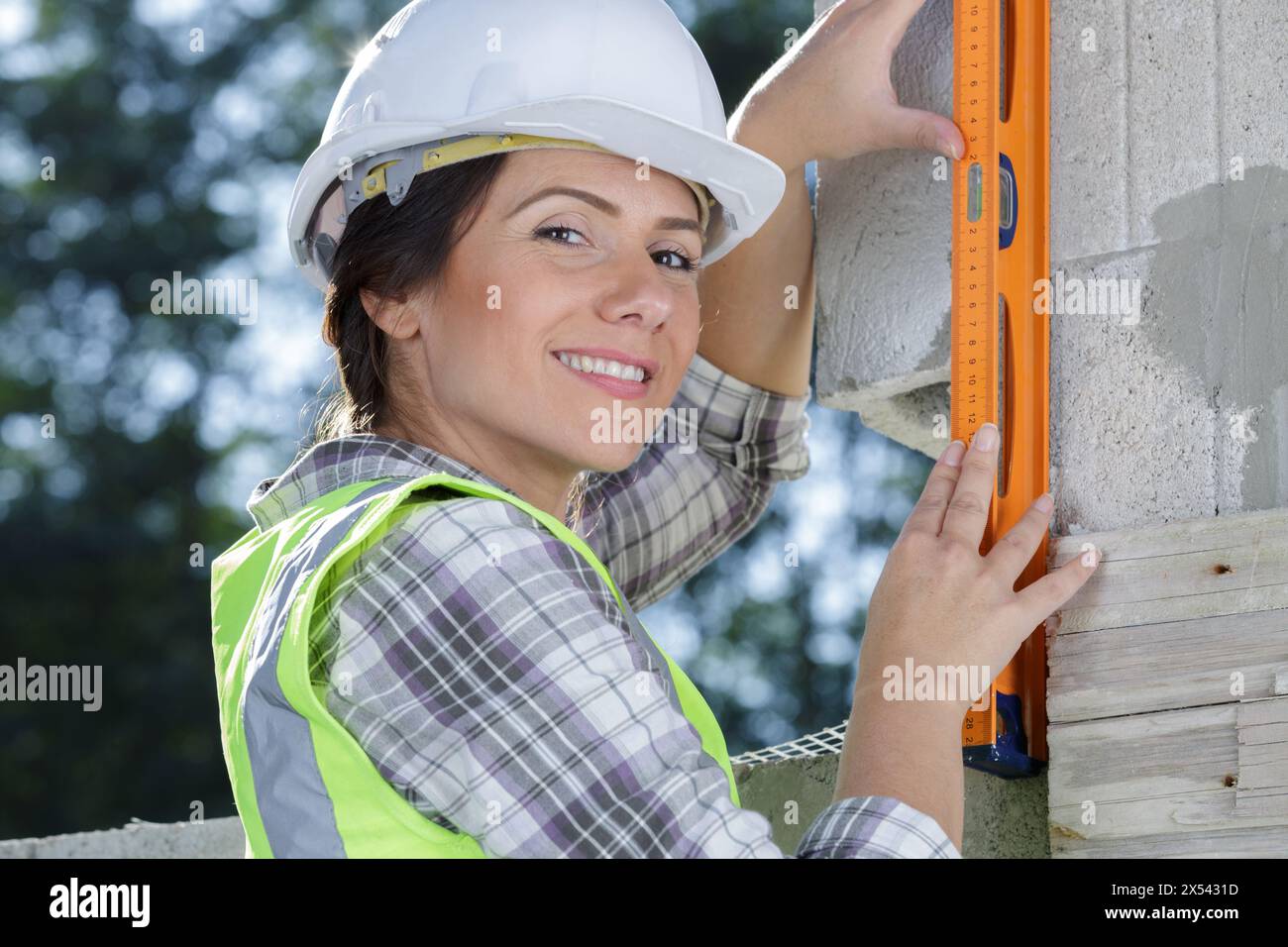 woman holding up a ruler and level marking a wall Stock Photo - Alamy