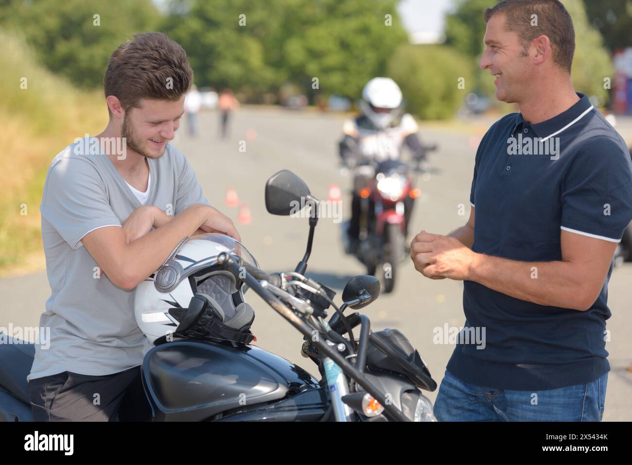 biker and young learning with motorcycle Stock Photo - Alamy