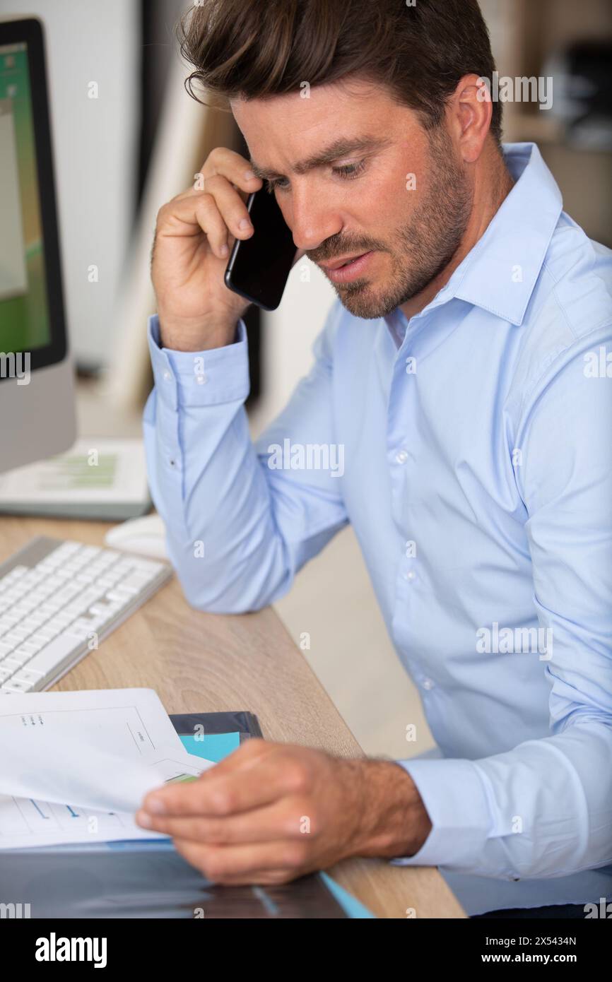young businessman discussing information from documents during mobile ...