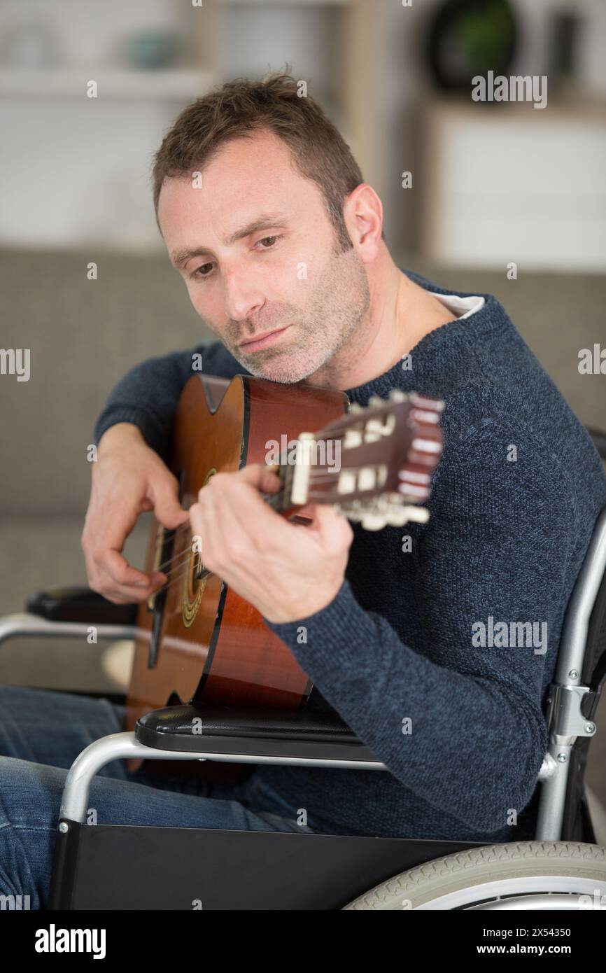 focused musician in a wheelchair playing guitar Stock Photo - Alamy