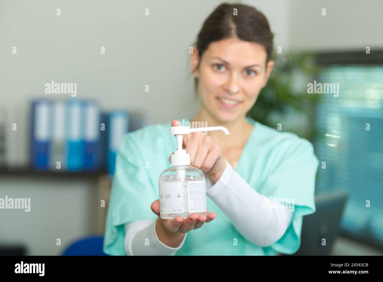 female doctor using sanitizer dispenser in washroom Stock Photo - Alamy