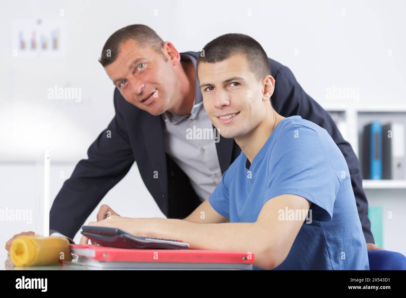 male teacher helping student and giving support Stock Photo - Alamy