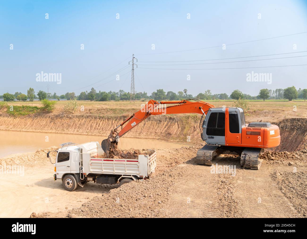 Excavator loading dumper trucks in construction site Stock Photo - Alamy