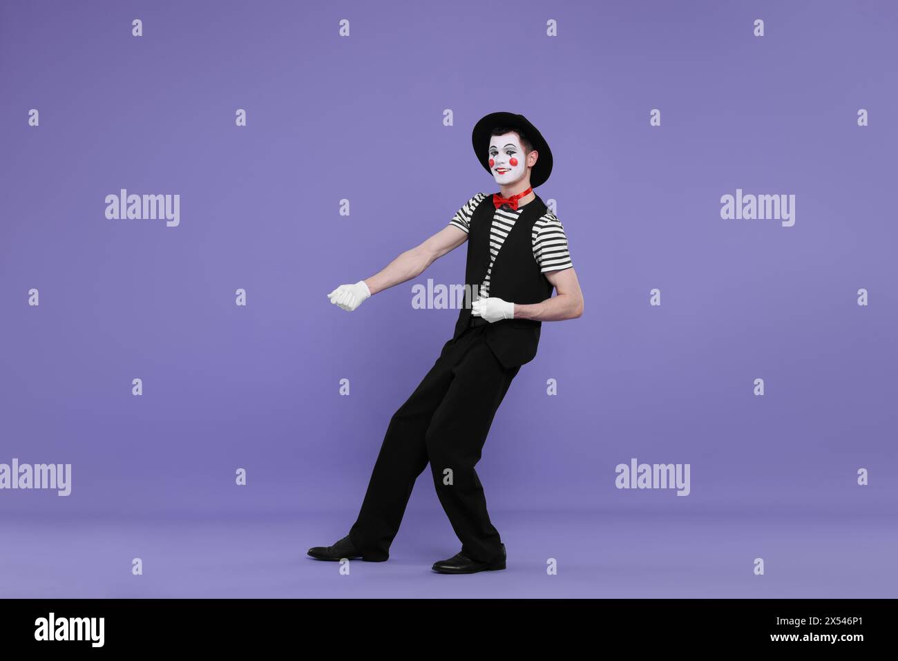 Funny mime artist in hat posing on purple background Stock Photo - Alamy
