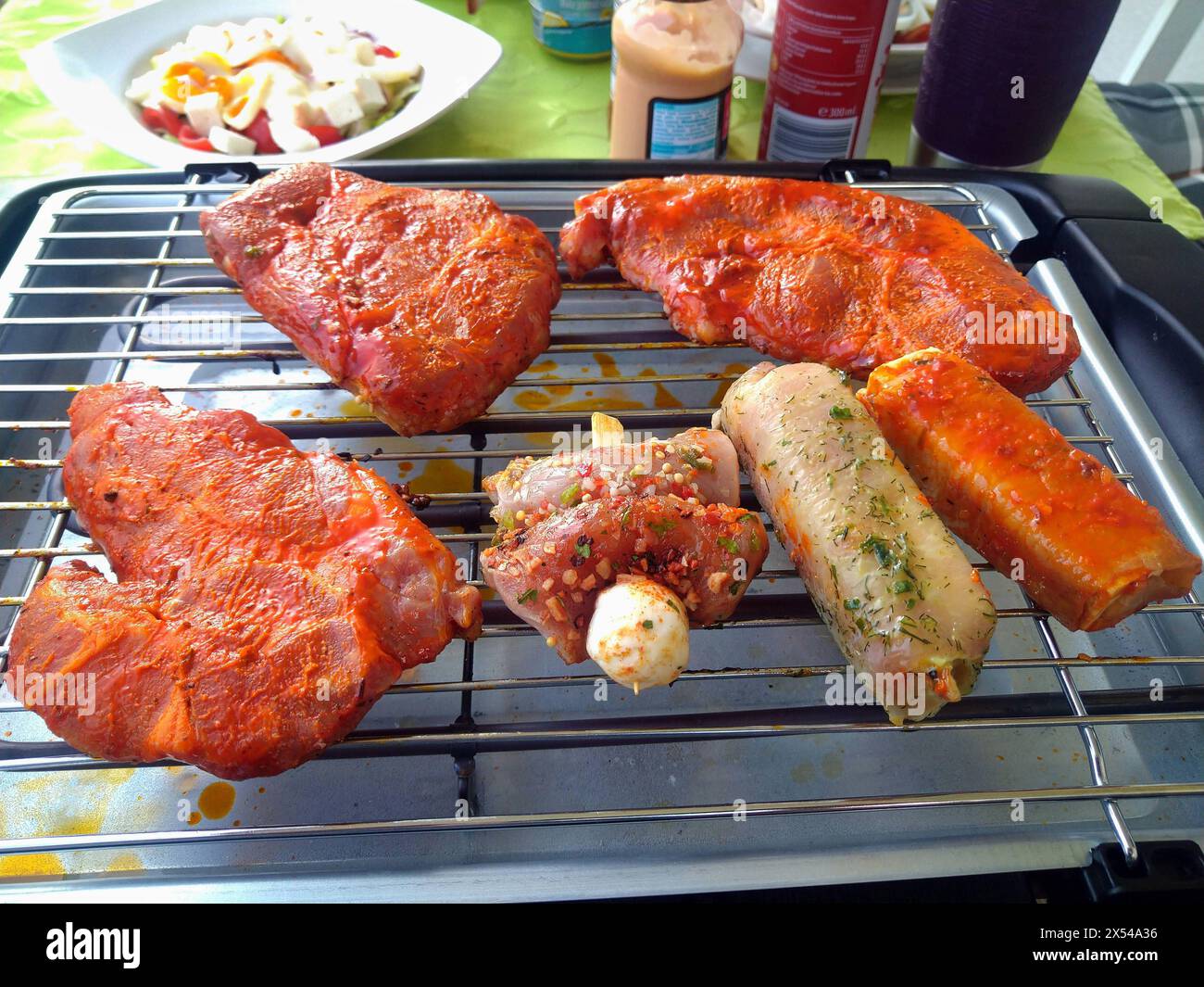 Grillgut auf einem Tischgrill im eigenen Garten. Grillsaison 2024 ...