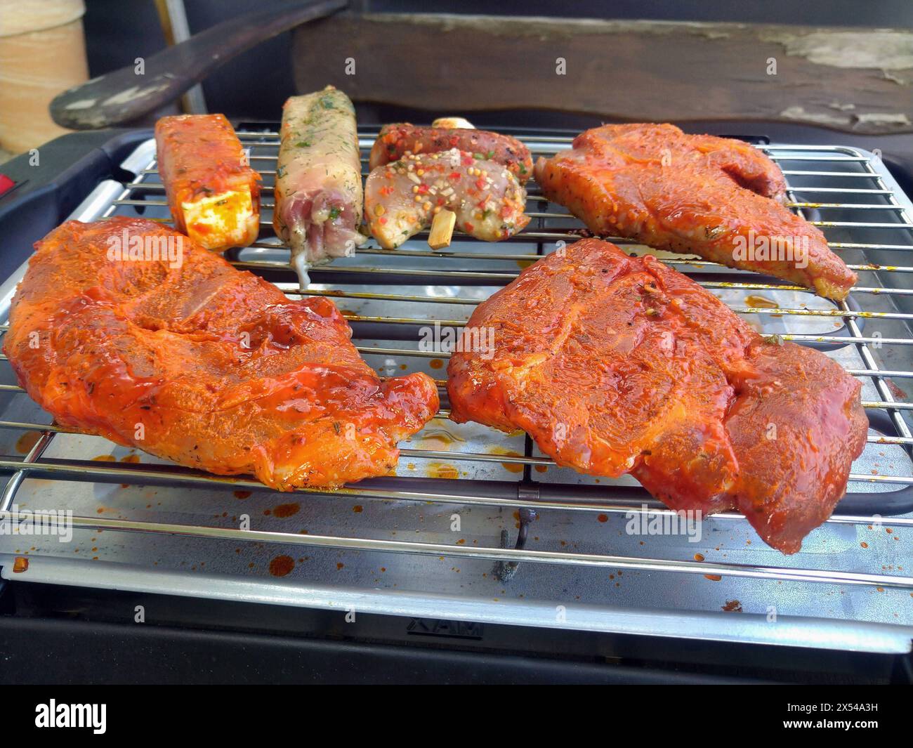 Grillgut auf einem Tischgrill im eigenen Garten. Grillsaison 2024 ...