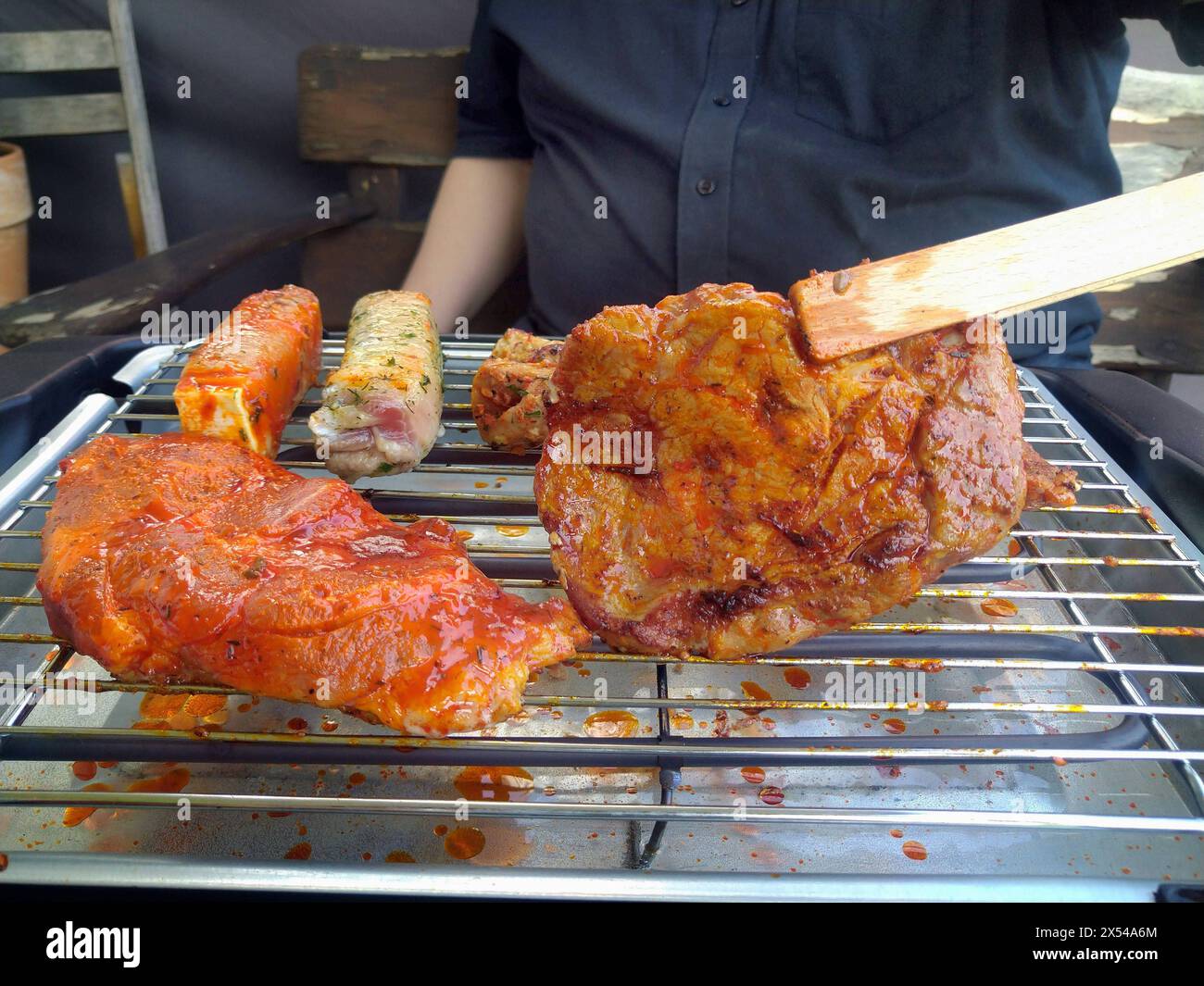 Grillgut auf einem Tischgrill im eigenen Garten. Grillsaison 2024 ...