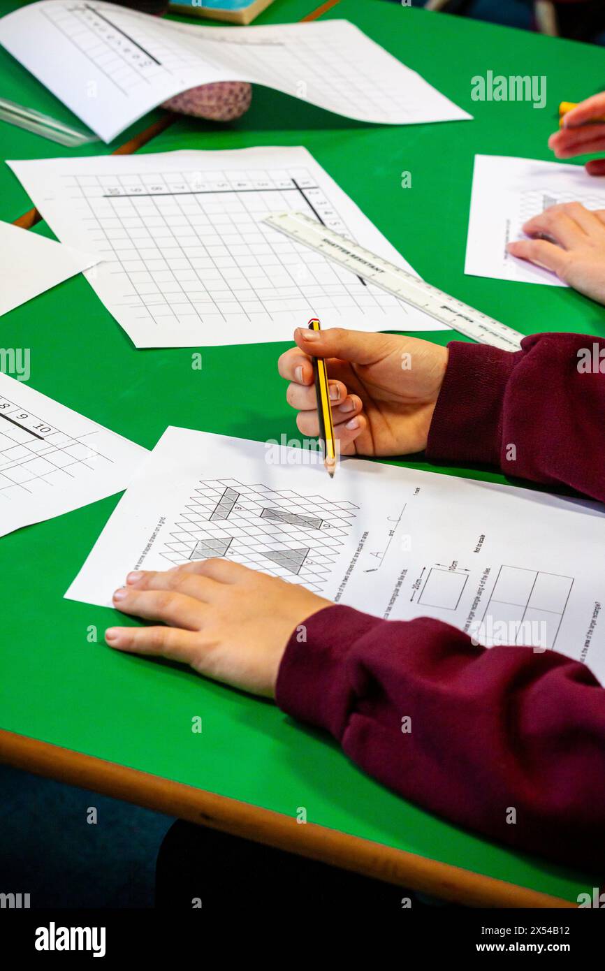 Primary school children writing on a desk during a lesson Stock Photo ...