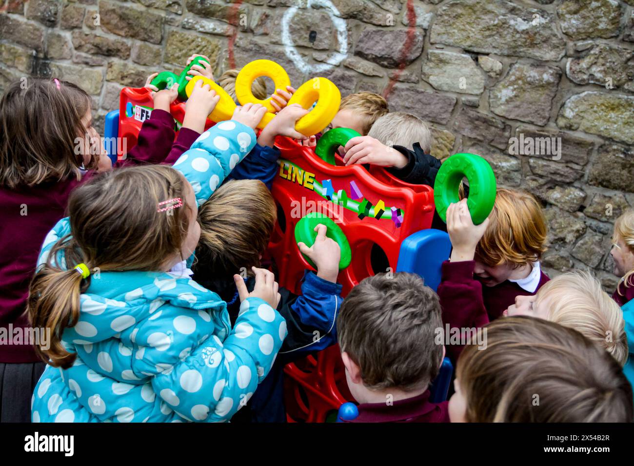 Primary school child playing with plastic rings outside in a school ...