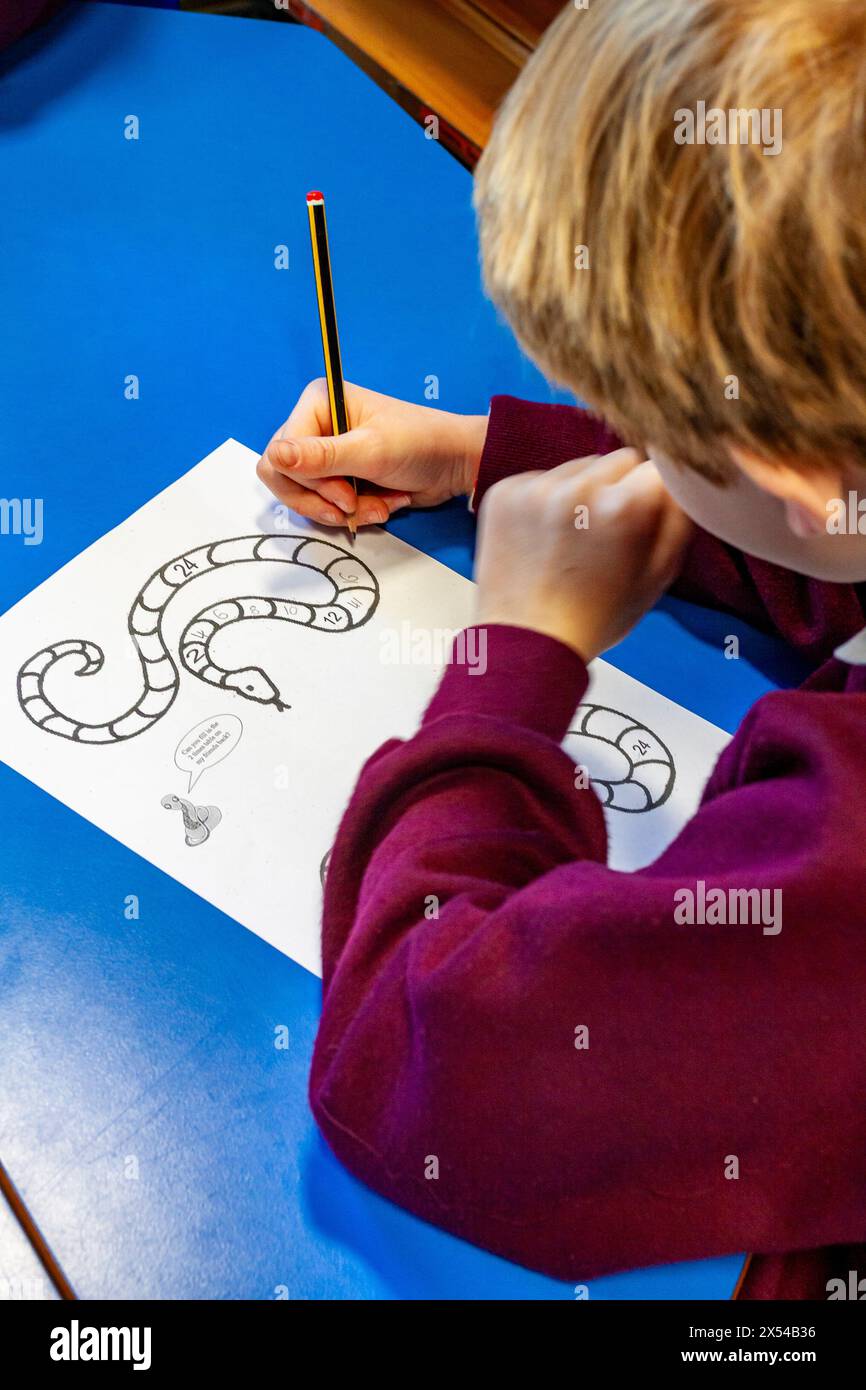 Primary school child writing on a desk during a lesson Stock Photo - Alamy