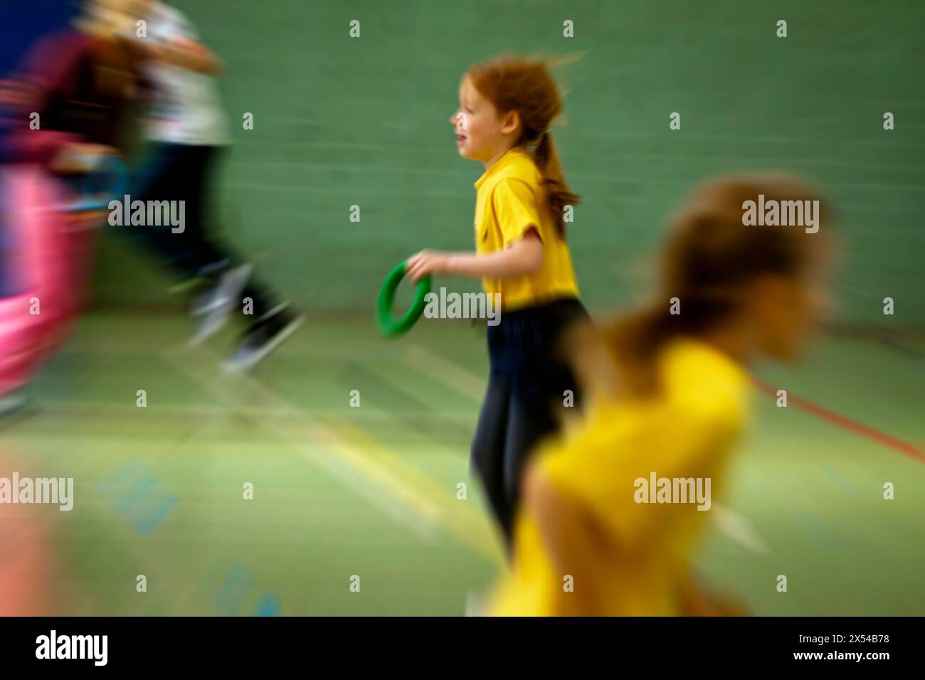 Primary school children taking part in a PE lesson with blurred motion ...