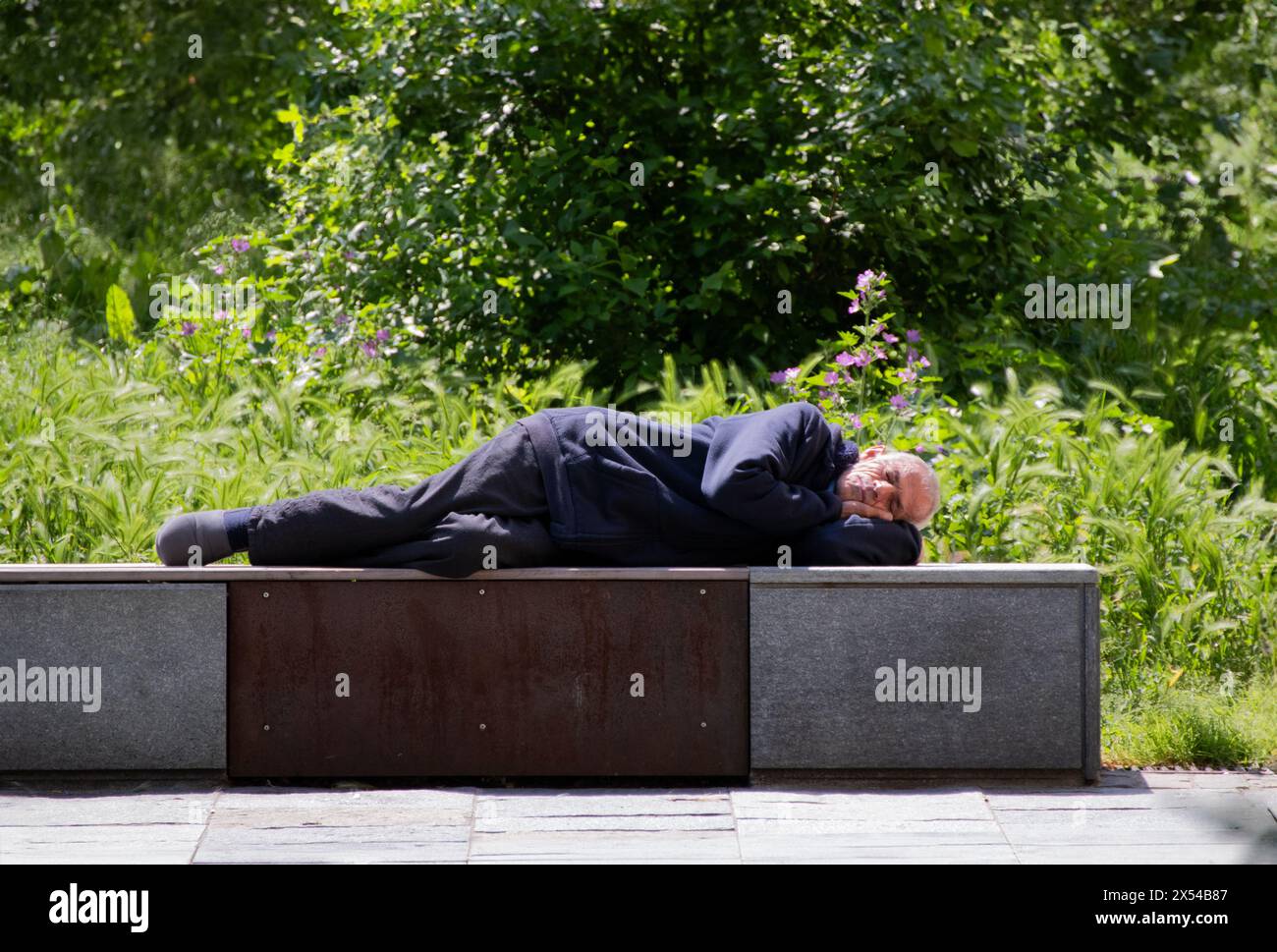 Elderly vagrant resting on park bench Stock Photo - Alamy