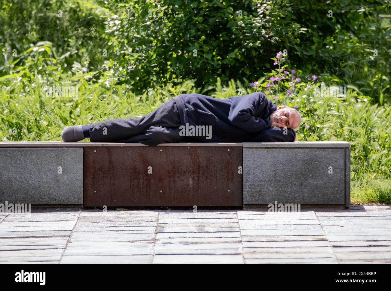 Elderly vagrant resting on park bench Stock Photo - Alamy